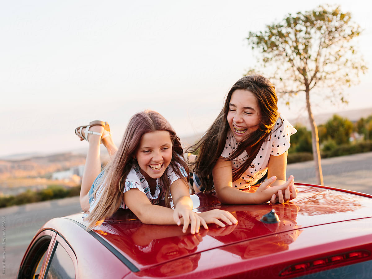 "Teenage Girls Laughing At Sunset On Top Of A Red Car." by Stocksy ...