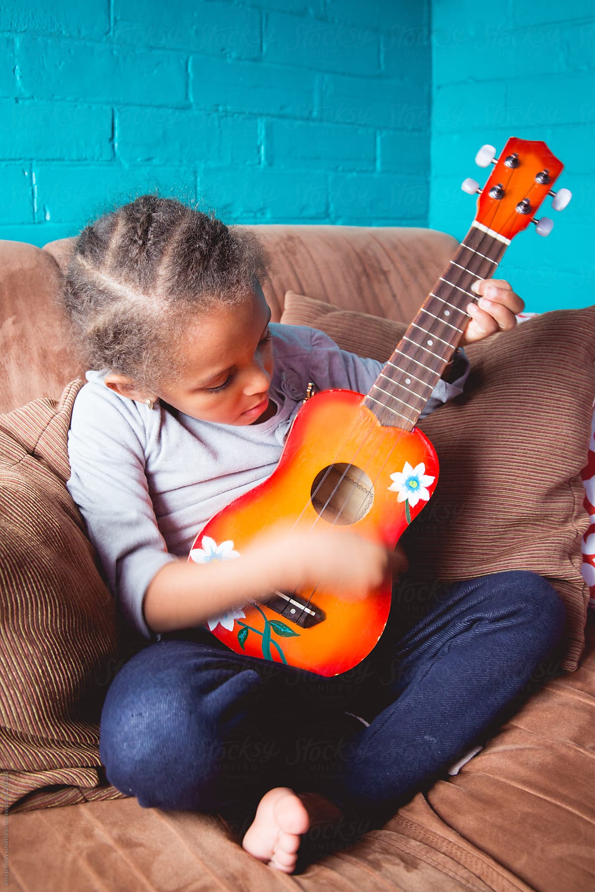 "A Young Girl With Braided Hair Strumming A Ukulele" by Stocksy ...