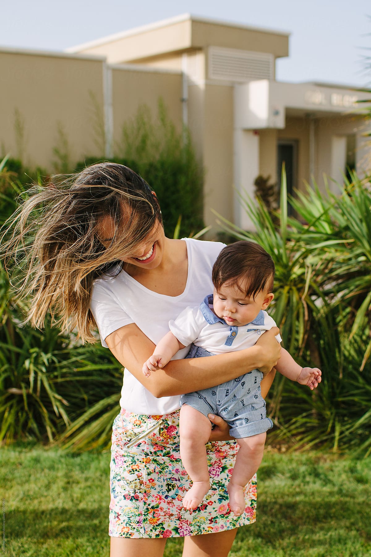 "Beautiful Windswept Woman Carrying Young Child In Front Of An ...