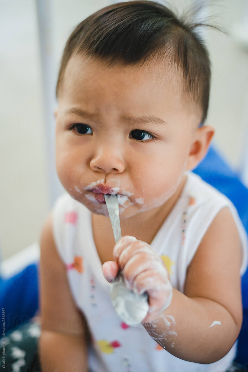"Asian Baby Eating Yogurt" by Stocksy Contributor "Chalit Saphaphak ...