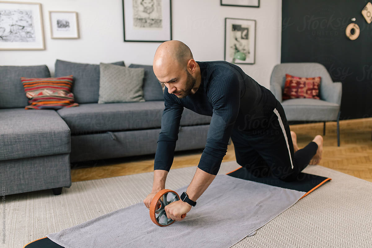 "Young Man Doing Home Workout" by Stocksy Contributor "Mihajlo Ckovric ...
