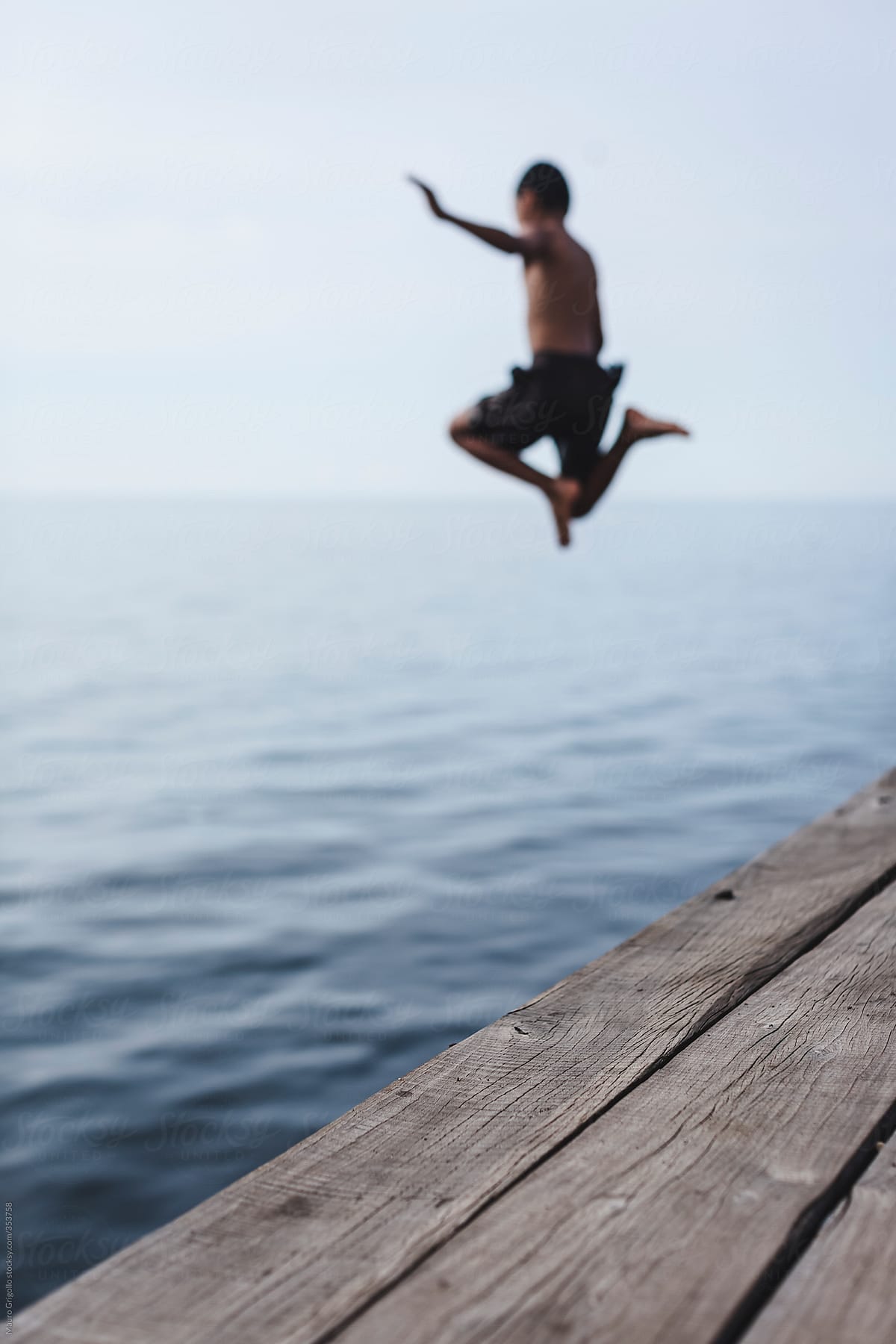 "Boy Jumping From The Jetty" by Stocksy Contributor "Mauro Grigollo ...