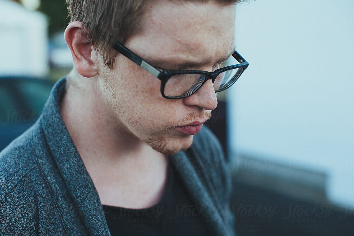 "Young Man With Glasses Stare At The Ground With A Pensive Face" by ...