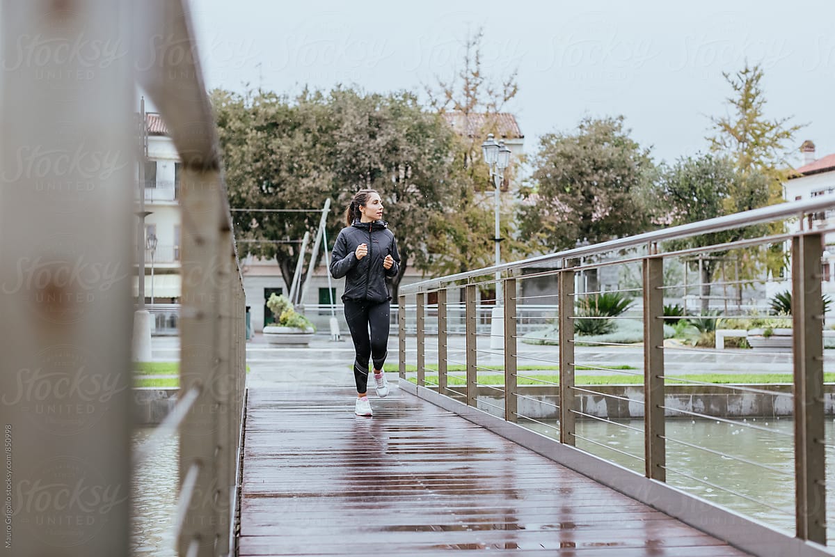 "A Woman Runs Outdoor On A Rainy Day" by Stocksy Contributor "Mauro ...