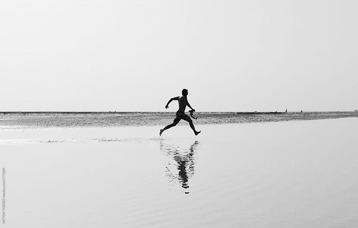 "Man Running Over A Sea Puddle" by Stocksy Contributor "VICTOR TORRES ...