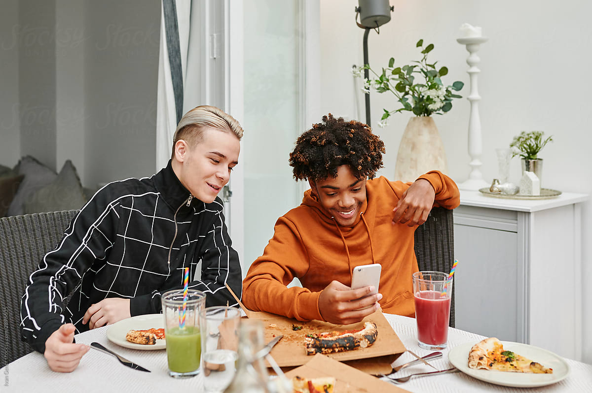 "Teens Eating Pizza And Using A Cellphone" by Stocksy Contributor "Ivan ...
