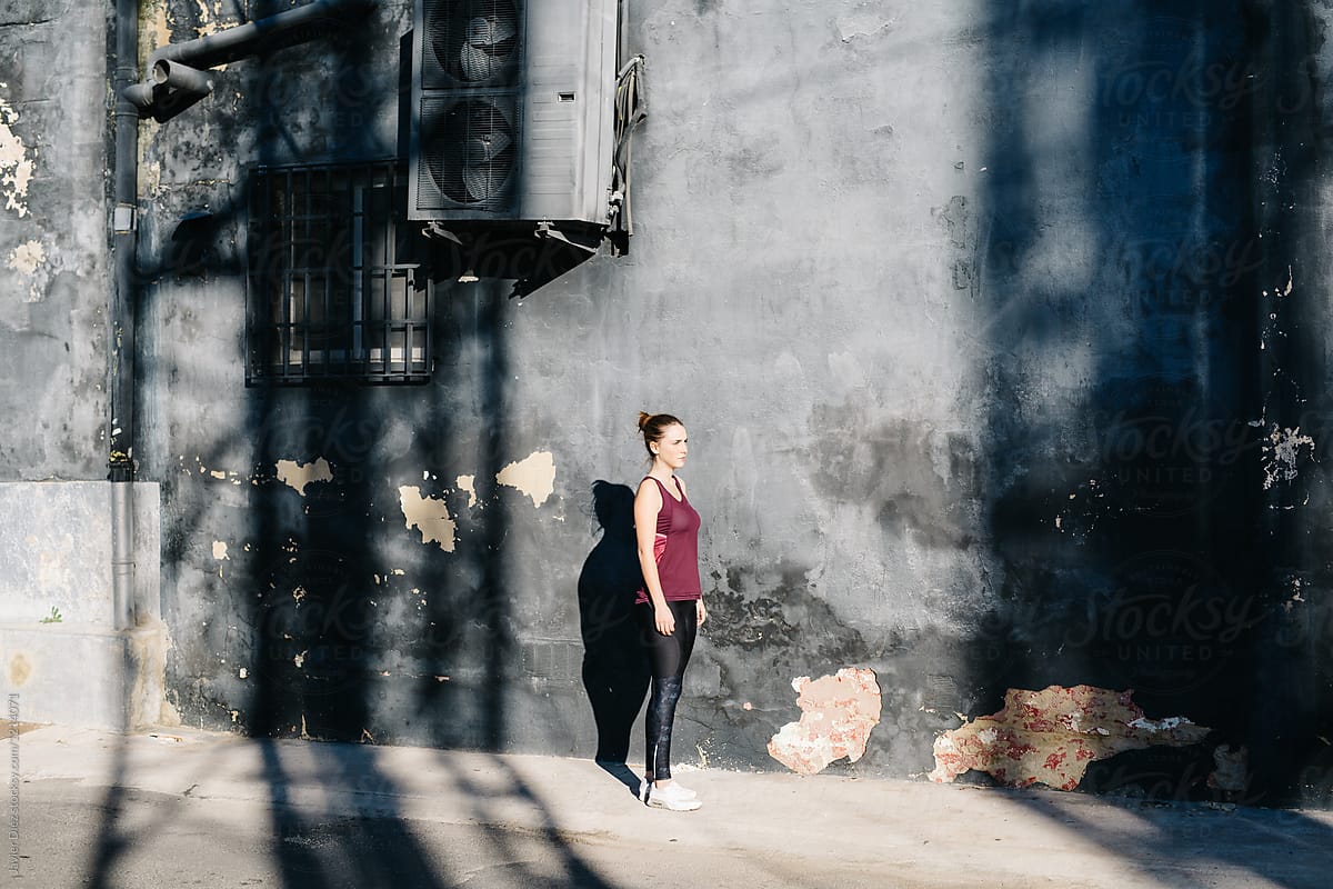 "Woman Standing Against Shabby Building" by Stocksy Contributor "Javier ...