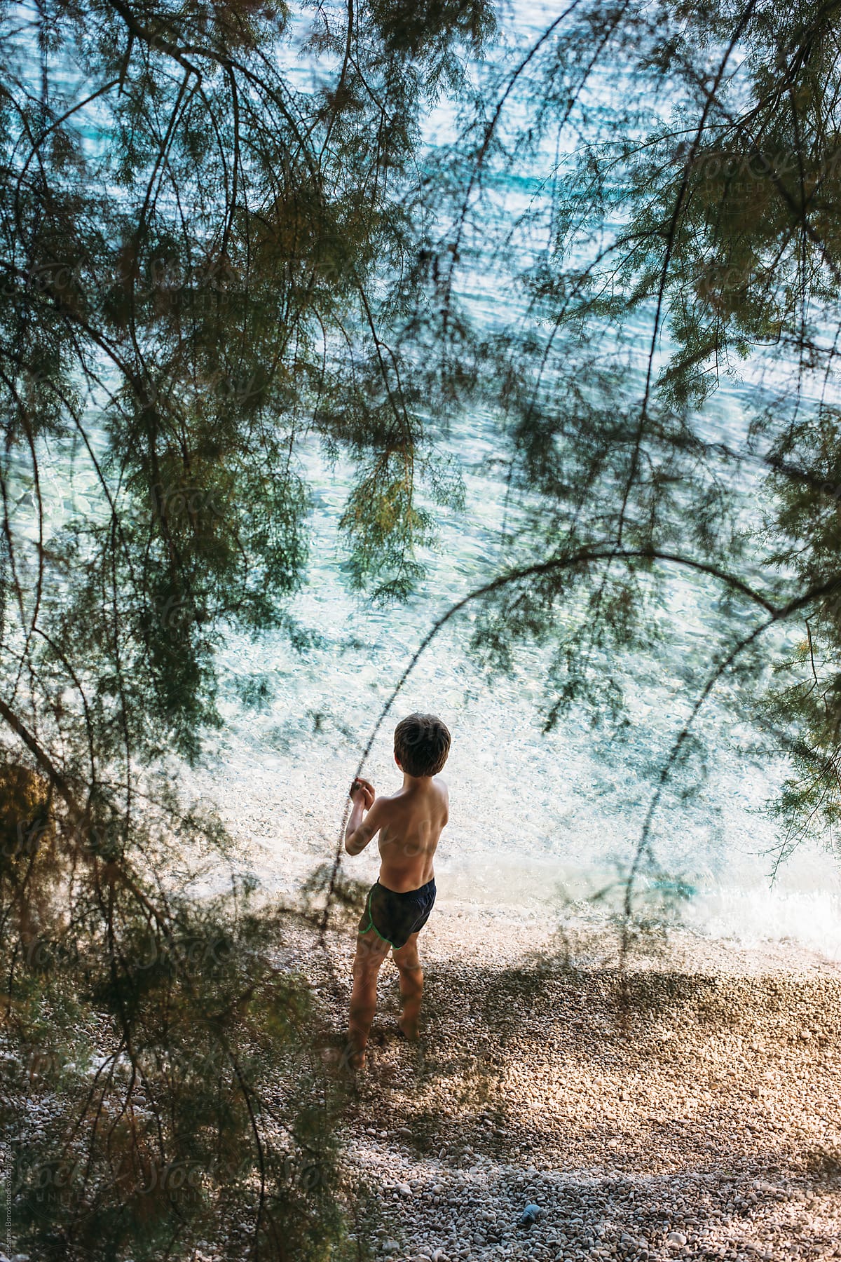 "6 Years Old Boy Playing With Pebbles On The Beach, Captured From ...