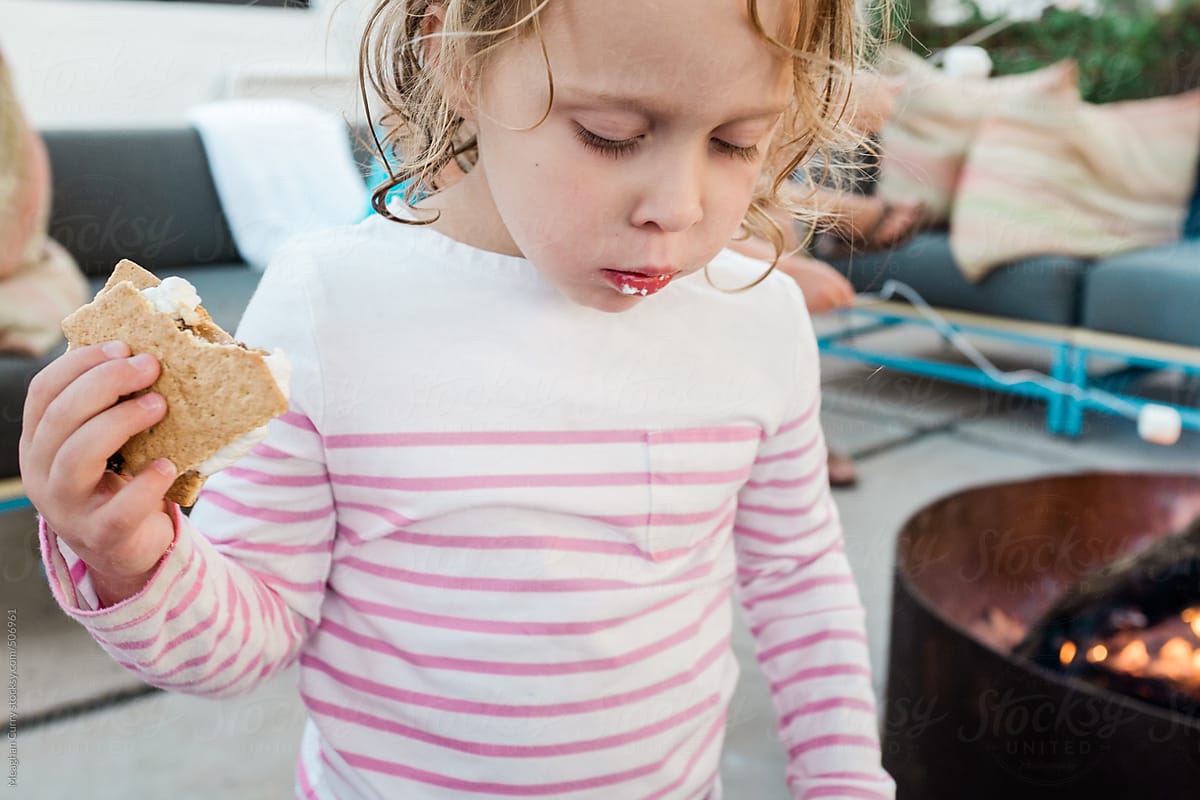 "Little Girl Eating Smores Around A Campfire" by Stocksy Contributor ...