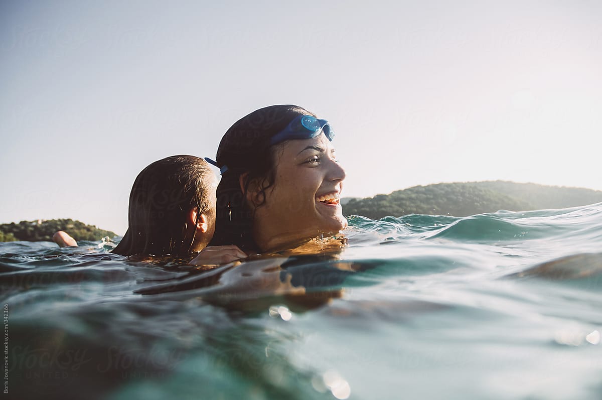 "Happy Friends Swimming" by Stocksy Contributor "Boris Jovanovic" - Stocksy