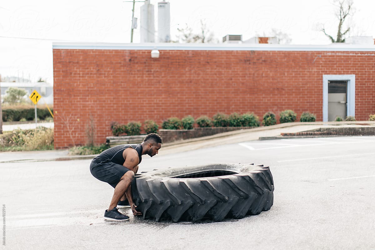 "Strong And Fit African American Athlete Flipping A Tractor Tire" by ...