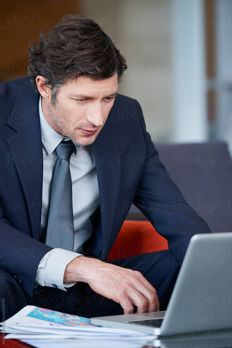 "Good Looking Businessman Doing Research On His Laptop" by Stocksy ...
