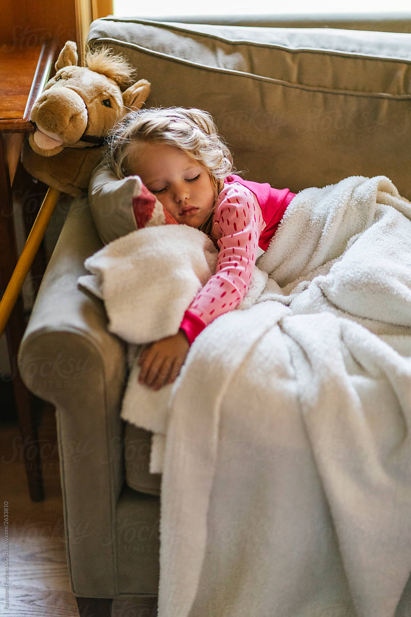 "Little Girl Napping Hygge On Couch With Stick Horse" by Stocksy ...