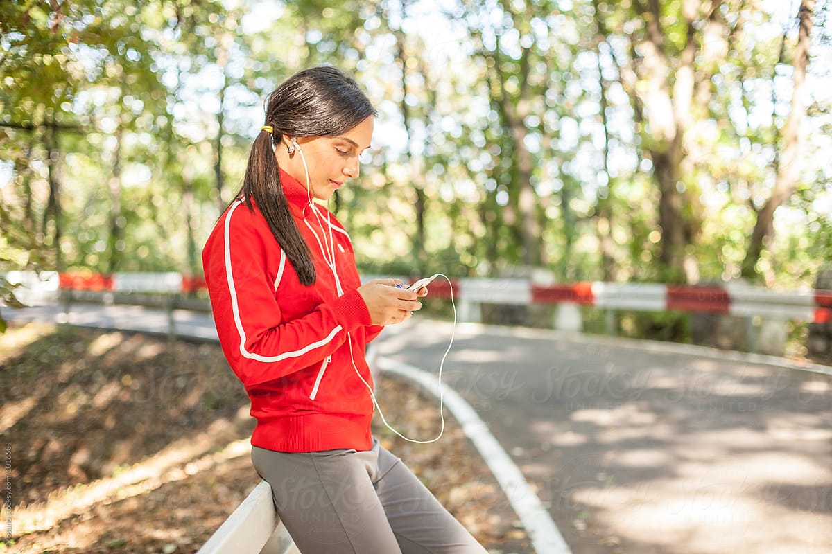 "Female Runner Using Smartphone" by Stocksy Contributor "Mosuno" - Stocksy