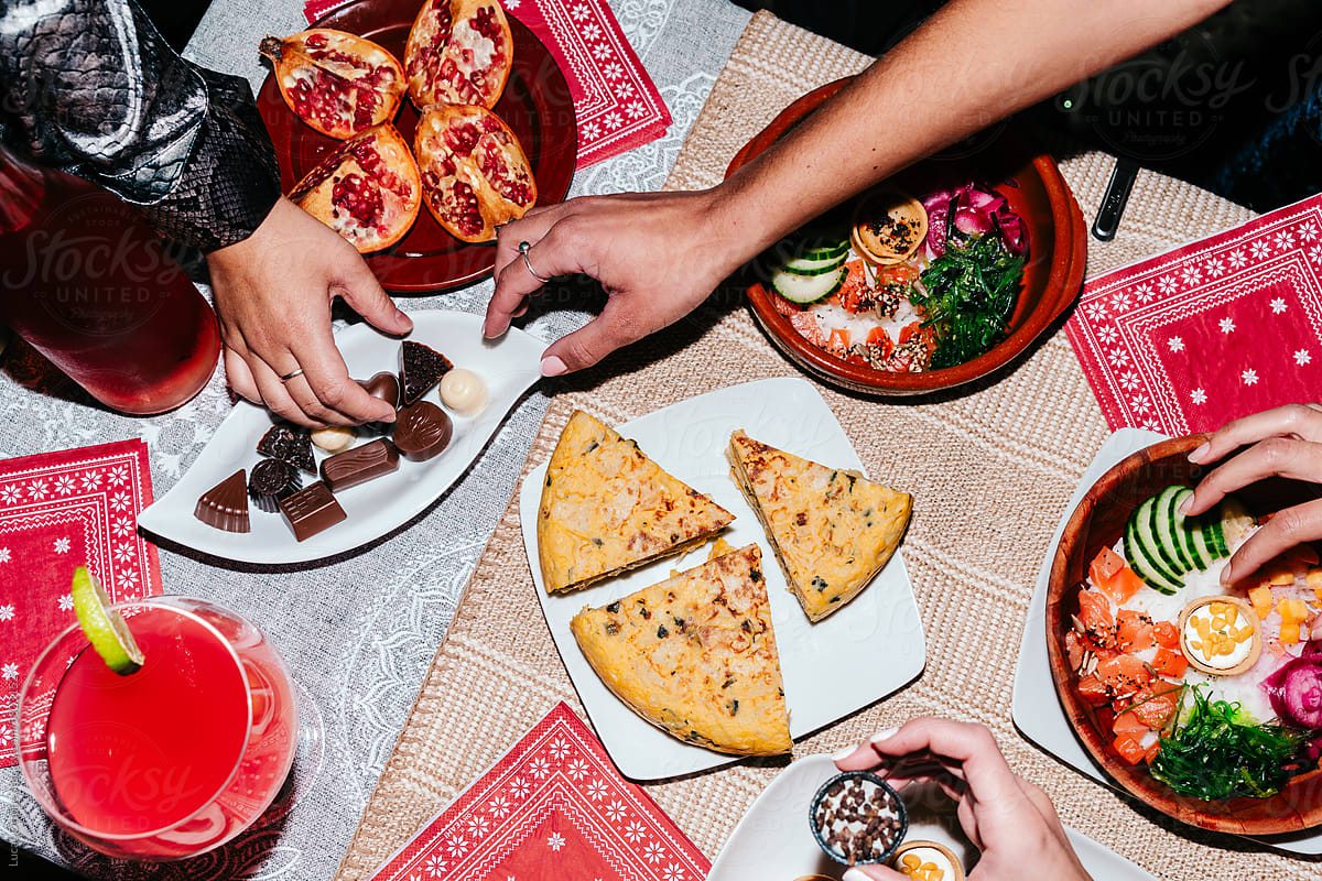 "Hands Reaching For Food At Dinner Table" by Stocksy Contributor "Lucas ...