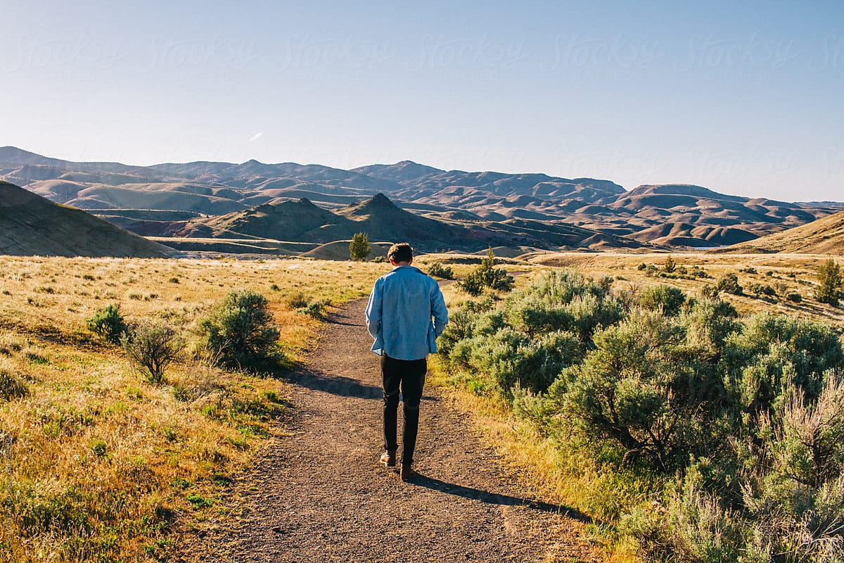 "Young Male Walking Down Path Near Painted Rolling Hills Oregon Usa" by ...