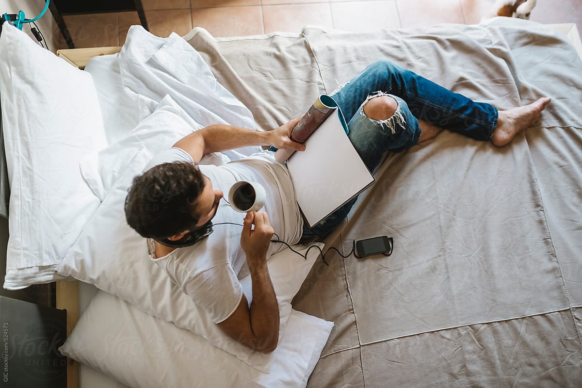 "Man Relaxing In The Bed Reading And Holding A Coffee Cup" by Stocksy ...