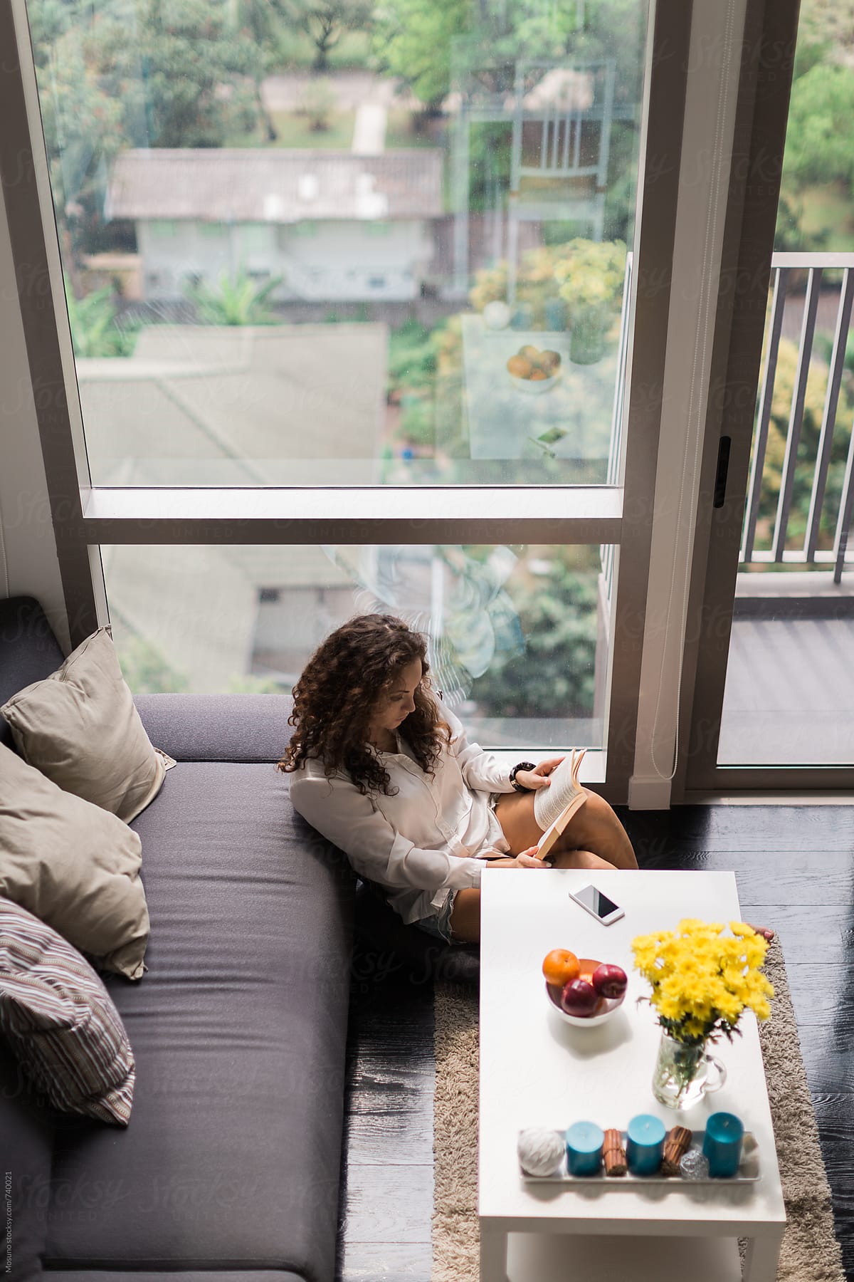 "Young Woman Reading A Book In The Living Room" by Stocksy Contributor ...