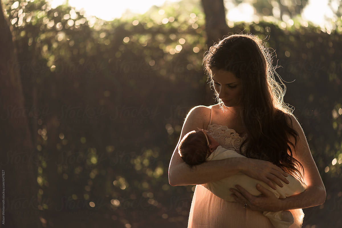 "A Mother Cradles Her Baby Outdoors" by Stocksy Contributor "Alison ...