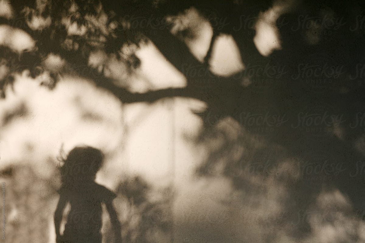 "Shadow Of Child With Hair Blowing Next To A Large Tree" by Stocksy ...