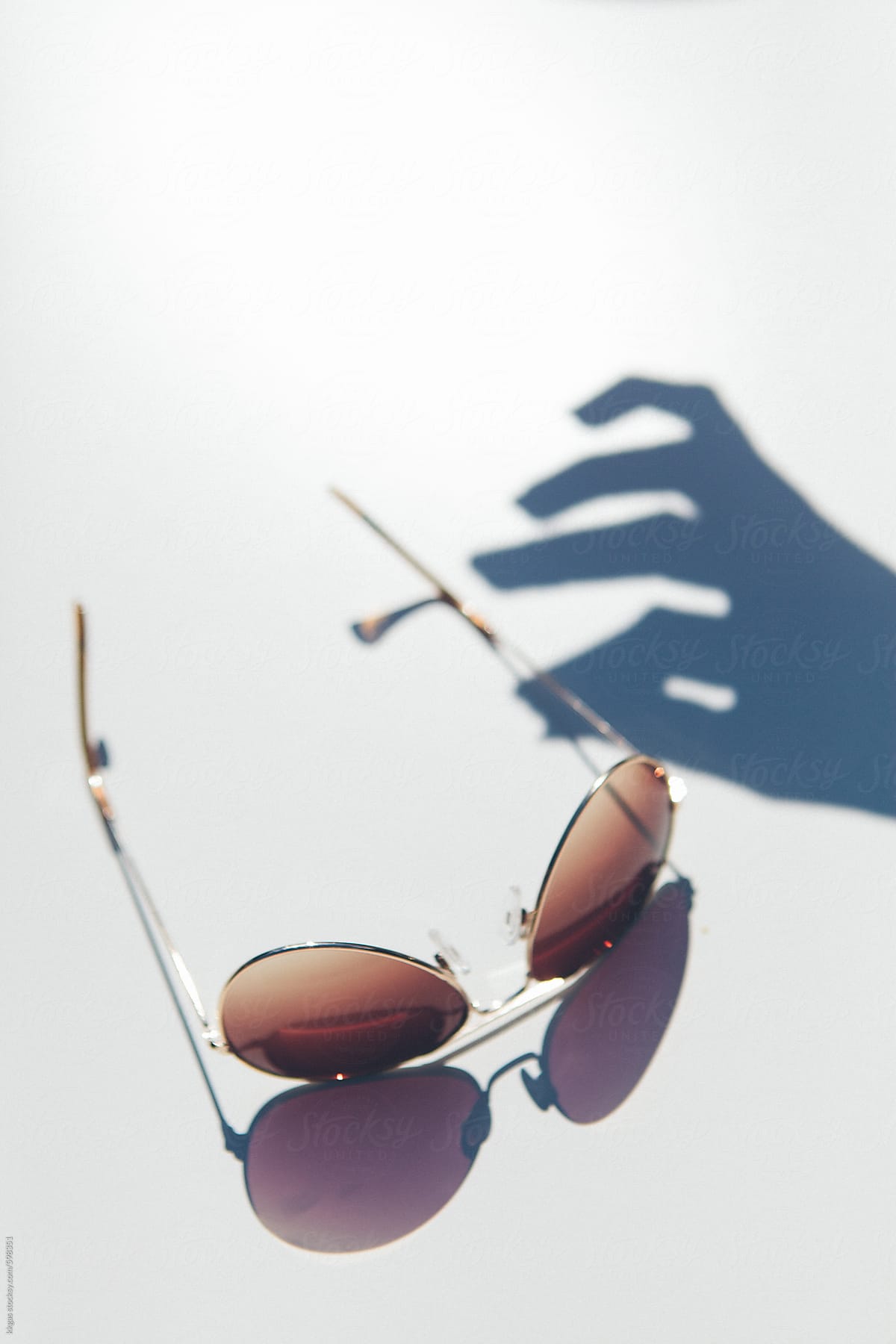 "Shadow Of Hand Picking Up Sunglasses" by Stocksy Contributor "Kkgas ...