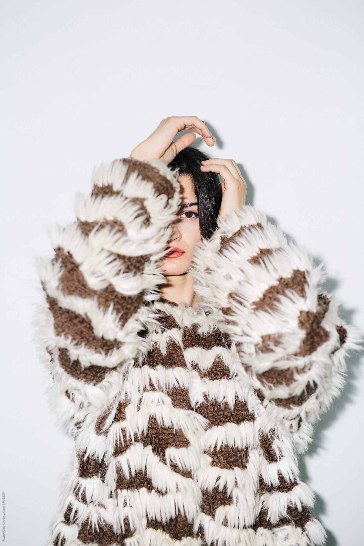 "Woman Posing In Coat" by Stocksy Contributor "Javier Díez" - Stocksy