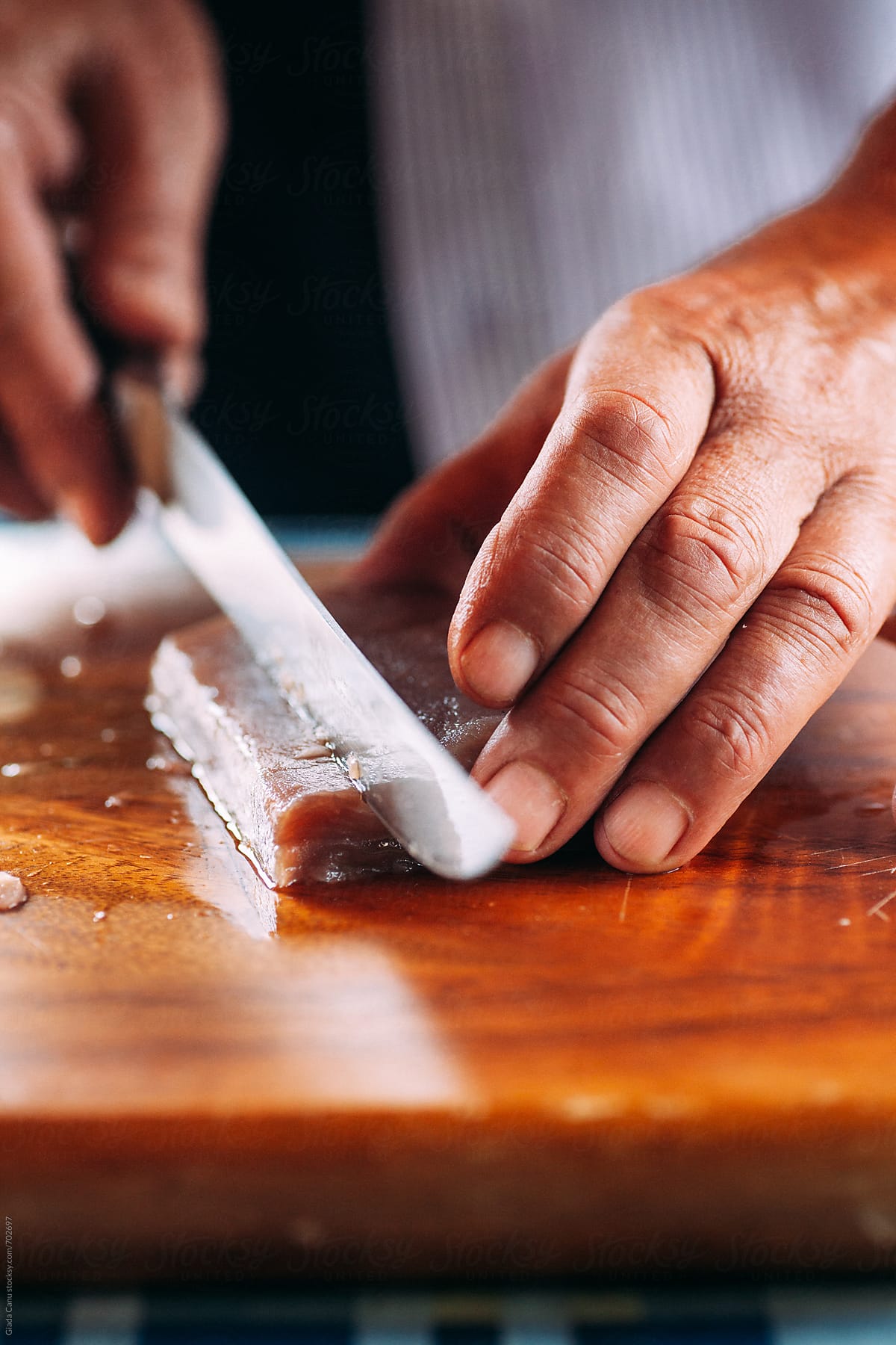 "Man Cutting Tuna" by Stocksy Contributor "Giada Canu" - Stocksy