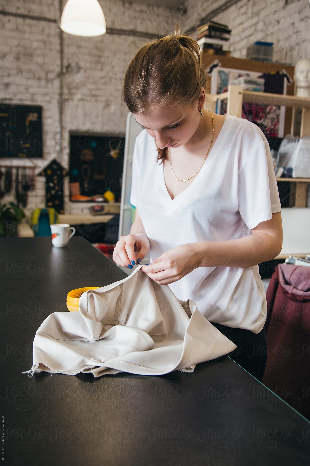 "She Sews Clothes" by Stocksy Contributor "Danil Nevsky" - Stocksy