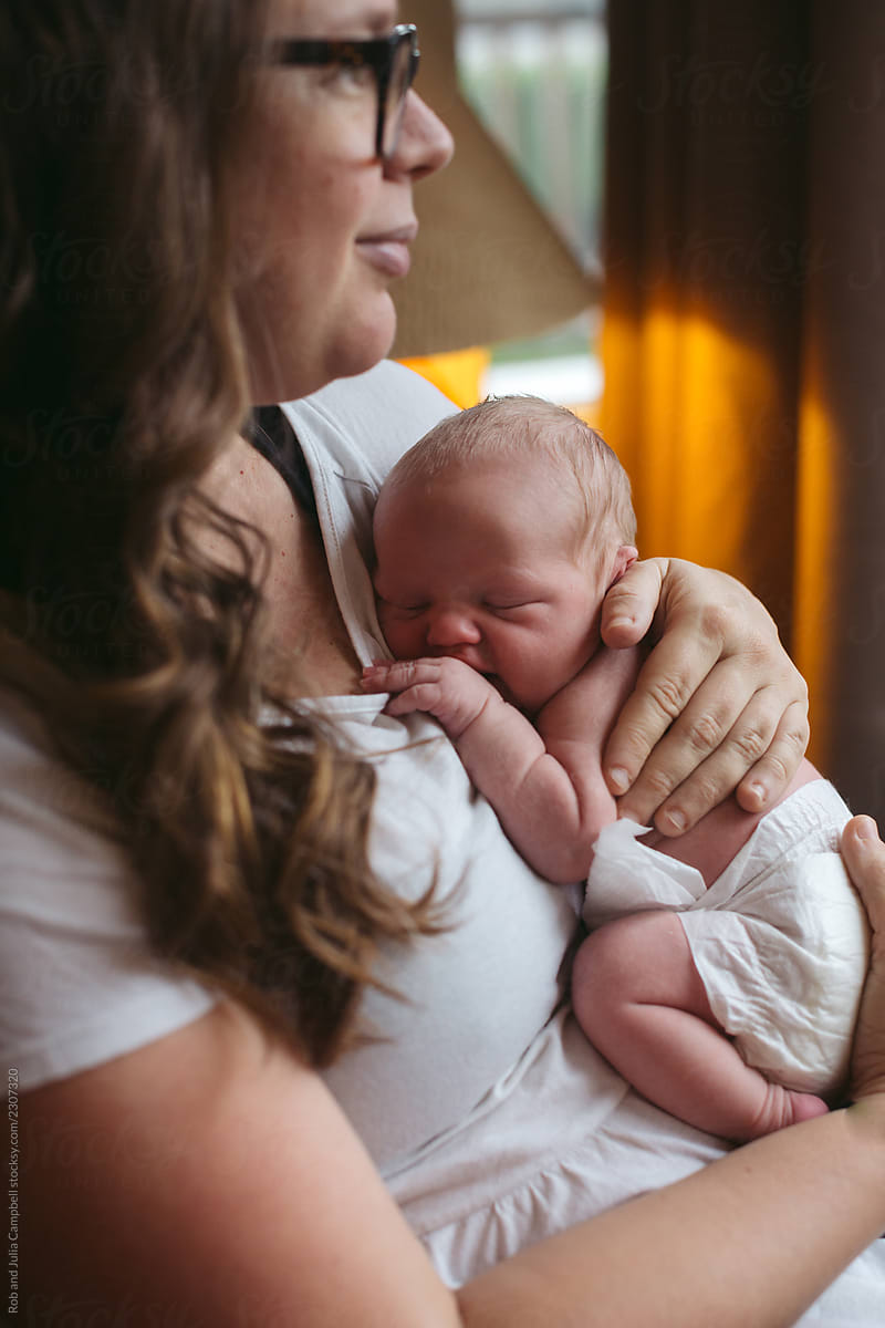 "Woman Holding Baby Inside" by Stocksy Contributor "Rob And Julia ...