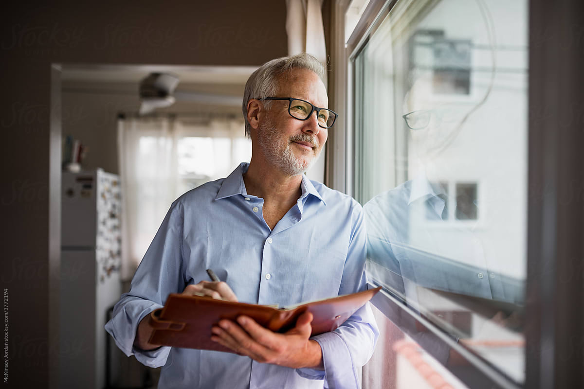 "Older Gentleman Writing In A Notebook Looks Out His Apartment Window ...
