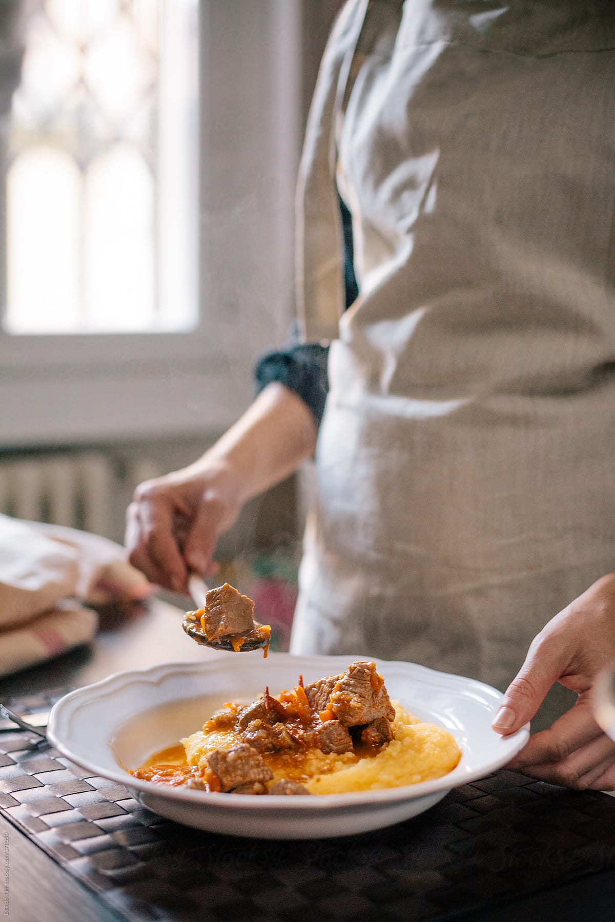 "Serving Beef Stew With Polenta" by Stocksy Contributor "Davide Illini ...