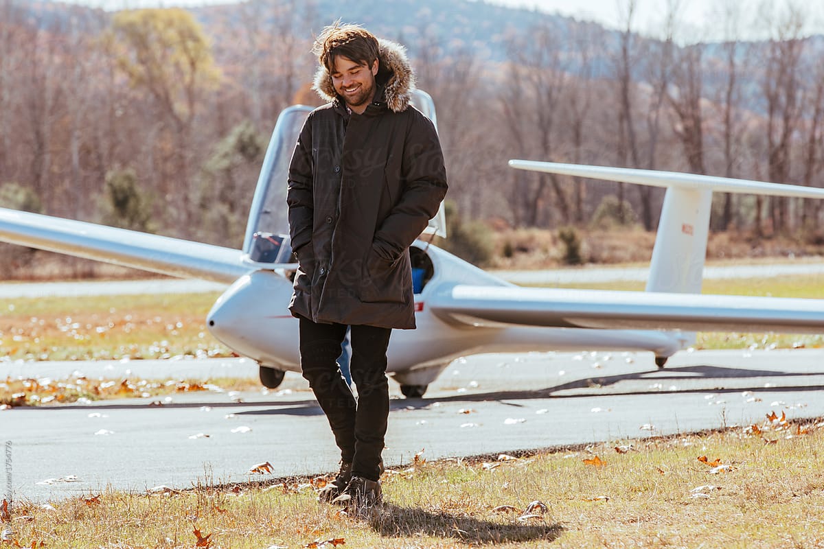 "Smiling Man Walking From His Glider Flight On An Airfield" by Stocksy ...