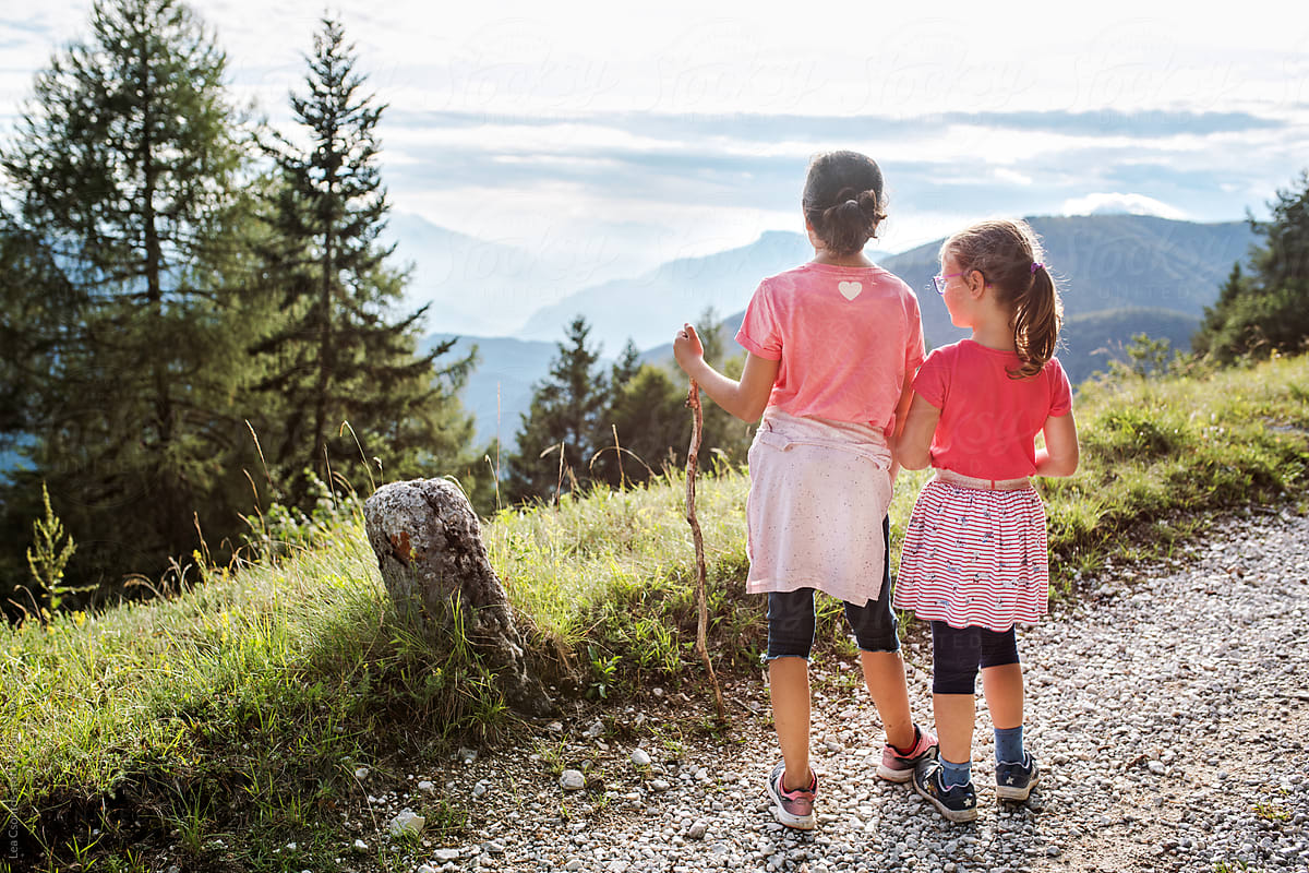 "Two Young Girls Enjoying The View While Hiking In The Mountains" by ...