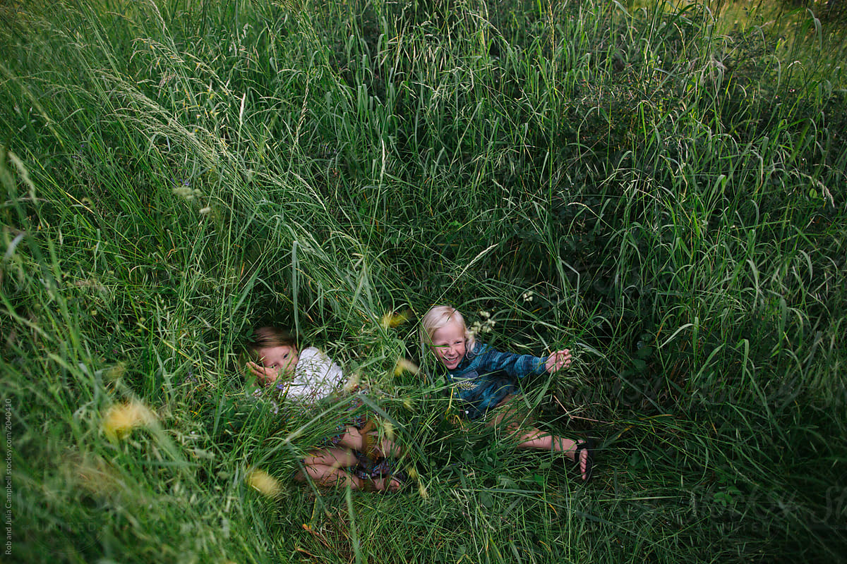 "Kids In Grass" by Stocksy Contributor "Rob And Julia Campbell" - Stocksy