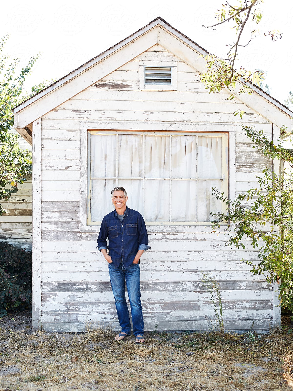 "Portrait Of Mature Man With Grey Hair In Front Of White Farmhouse" by ...