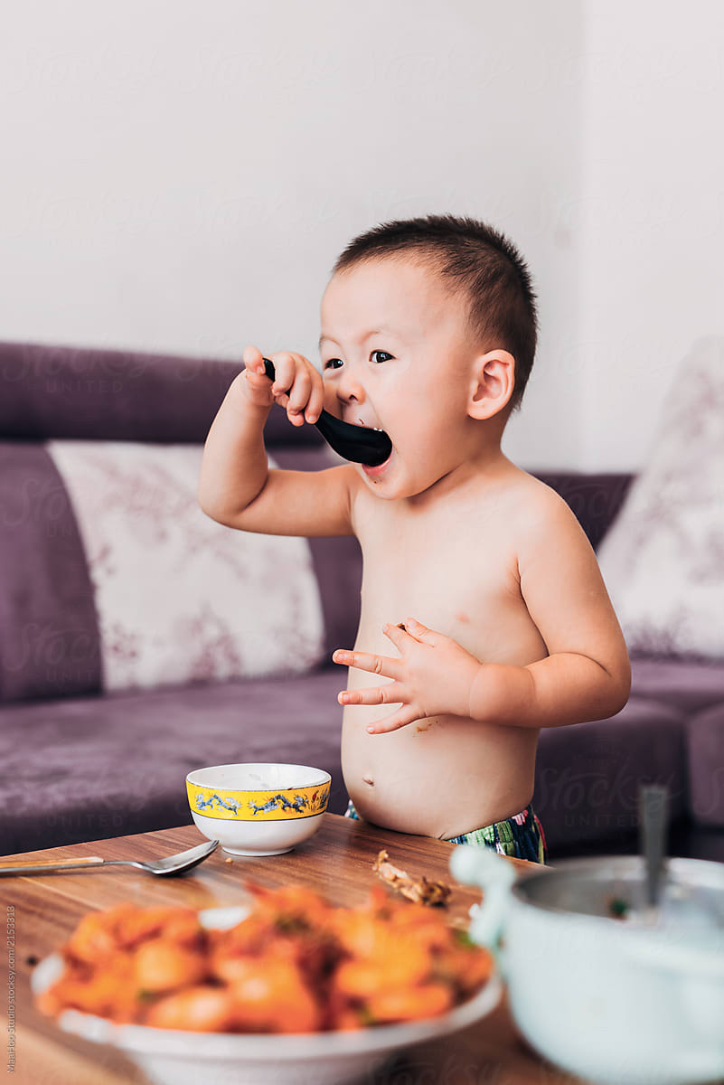 "Adorable Toddler Boy Eating At Home" by Stocksy Contributor "MaaHoo ...