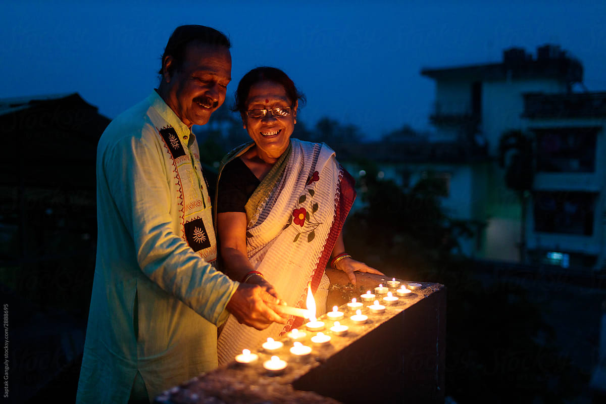"Senior Couple Lighting Candles At Twilight During Diwali" by Stocksy ...