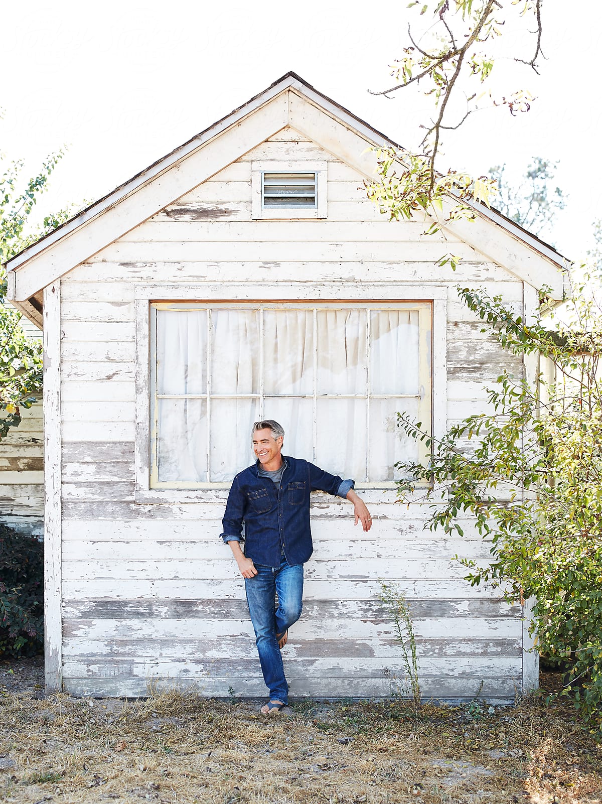 "Portrait Of Mature Man With Grey Hair In Front Of White Farmhouse" by ...