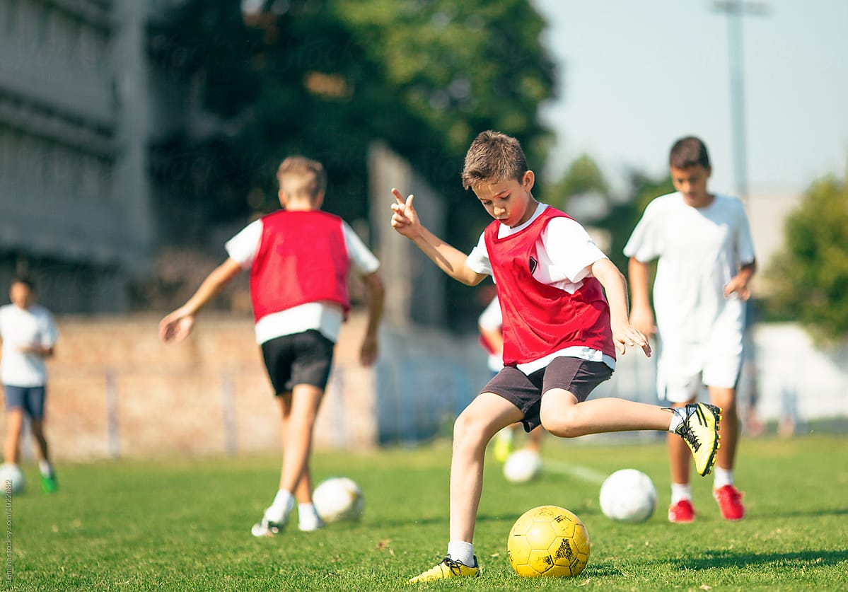 "Group Of Boys Playing Football" by Stocksy Contributor "Lumina" - Stocksy