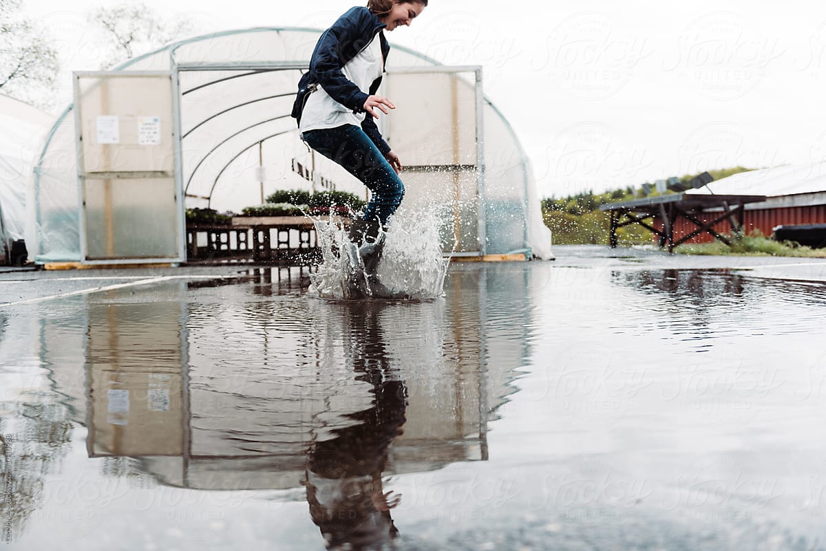 "Teen Jumping In A Puddle By A Greenhouse" by Stocksy Contributor "Lea ...