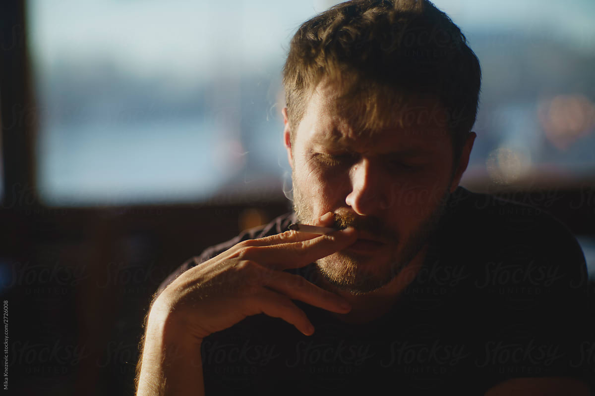 "Man Smoking In Bar" by Stocksy Contributor "Mika Knezevic" - Stocksy
