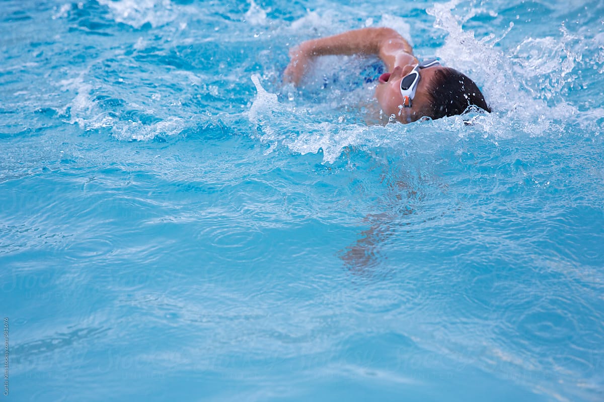 "Boy Swimming Laps In Pool" by Stocksy Contributor "Curtis Kim" - Stocksy