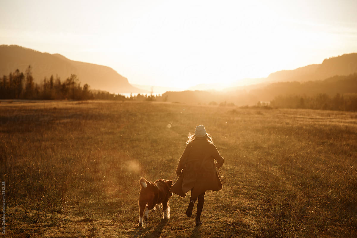 "Woman Running With Dog" by Stocksy Contributor "Caleb Gaskins" - Stocksy