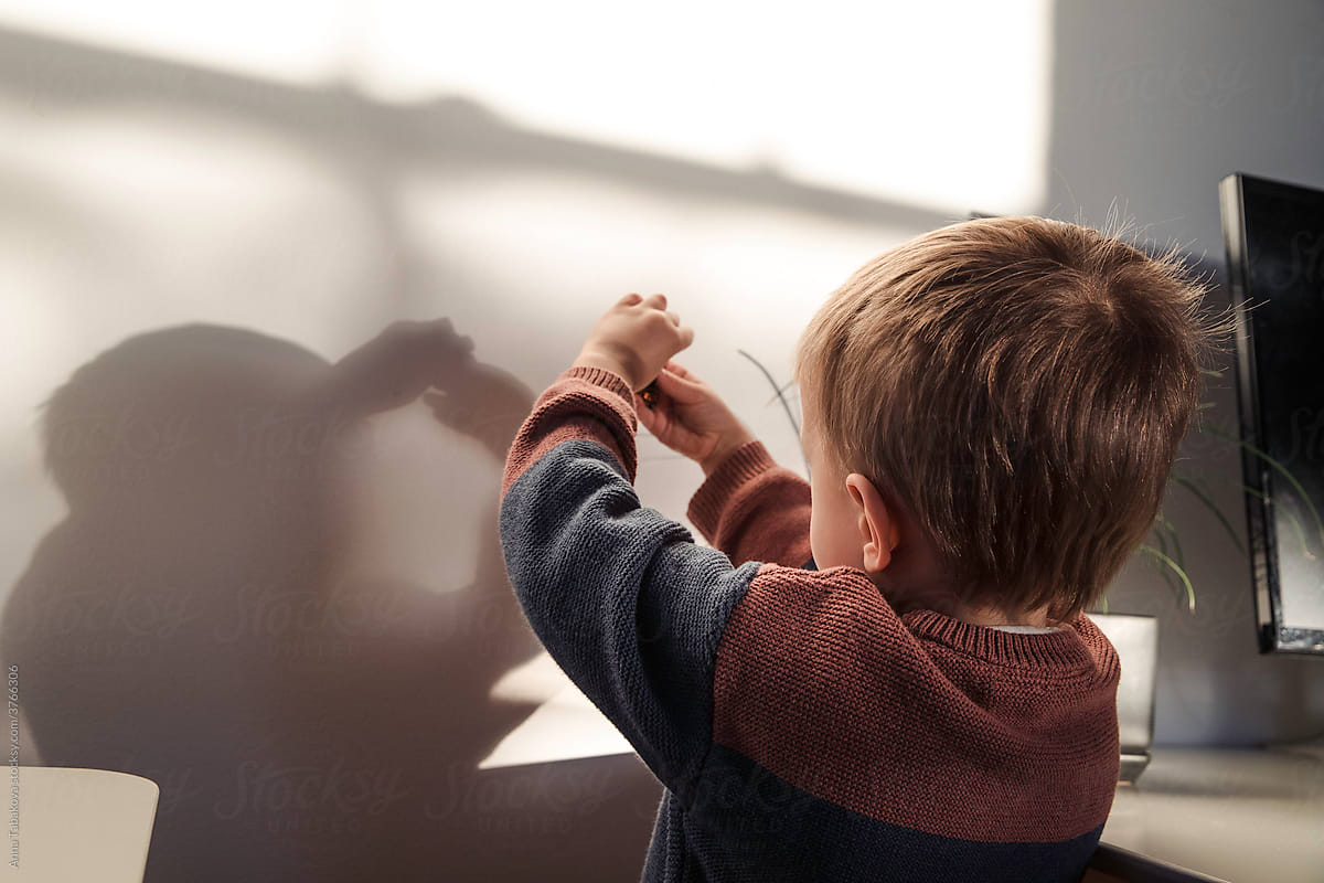 "Little Boy Playing Sun Shadows On The Wall" by Stocksy Contributor ...