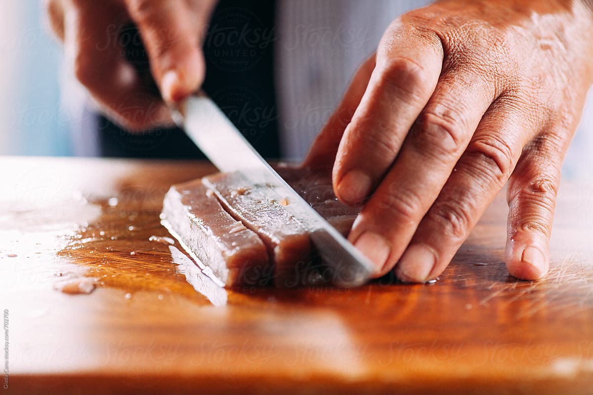 "Man Cutting Tuna" by Stocksy Contributor "Giada Canu" - Stocksy