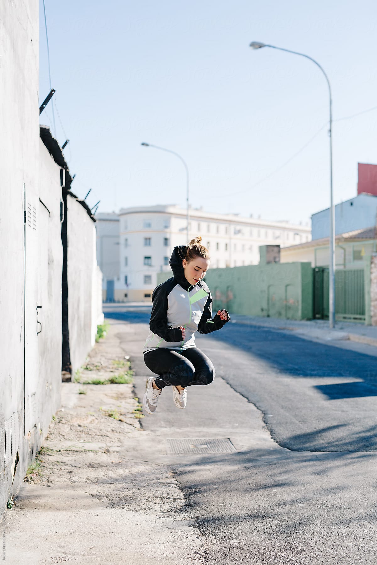 "Woman In Motion Of Jumping" by Stocksy Contributor "Javier Díez" - Stocksy