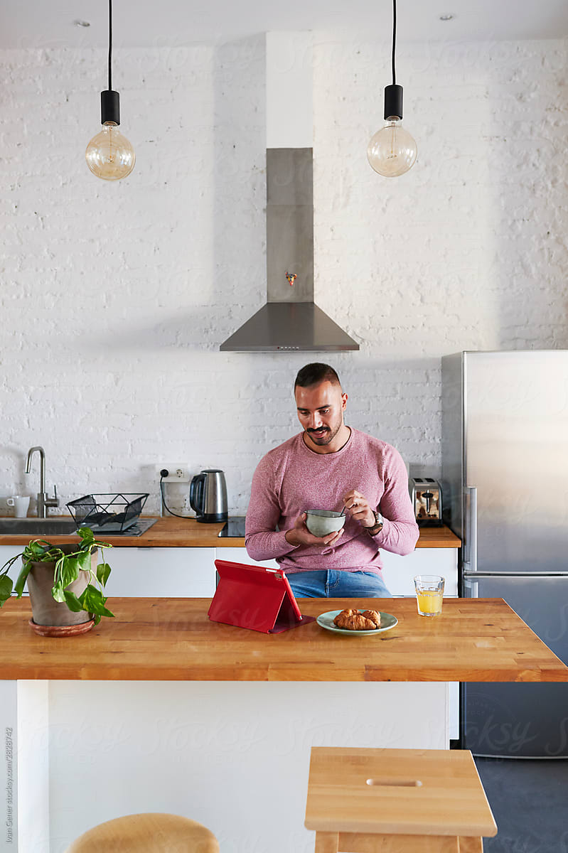 "Man Using A Table During Breakfast" by Stocksy Contributor "Ivan Gener ...