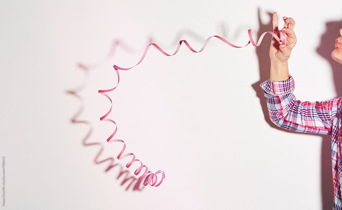 "Young Woman Blowing A Streamer" by Stocksy Contributor "Nasos Zovoilis ...