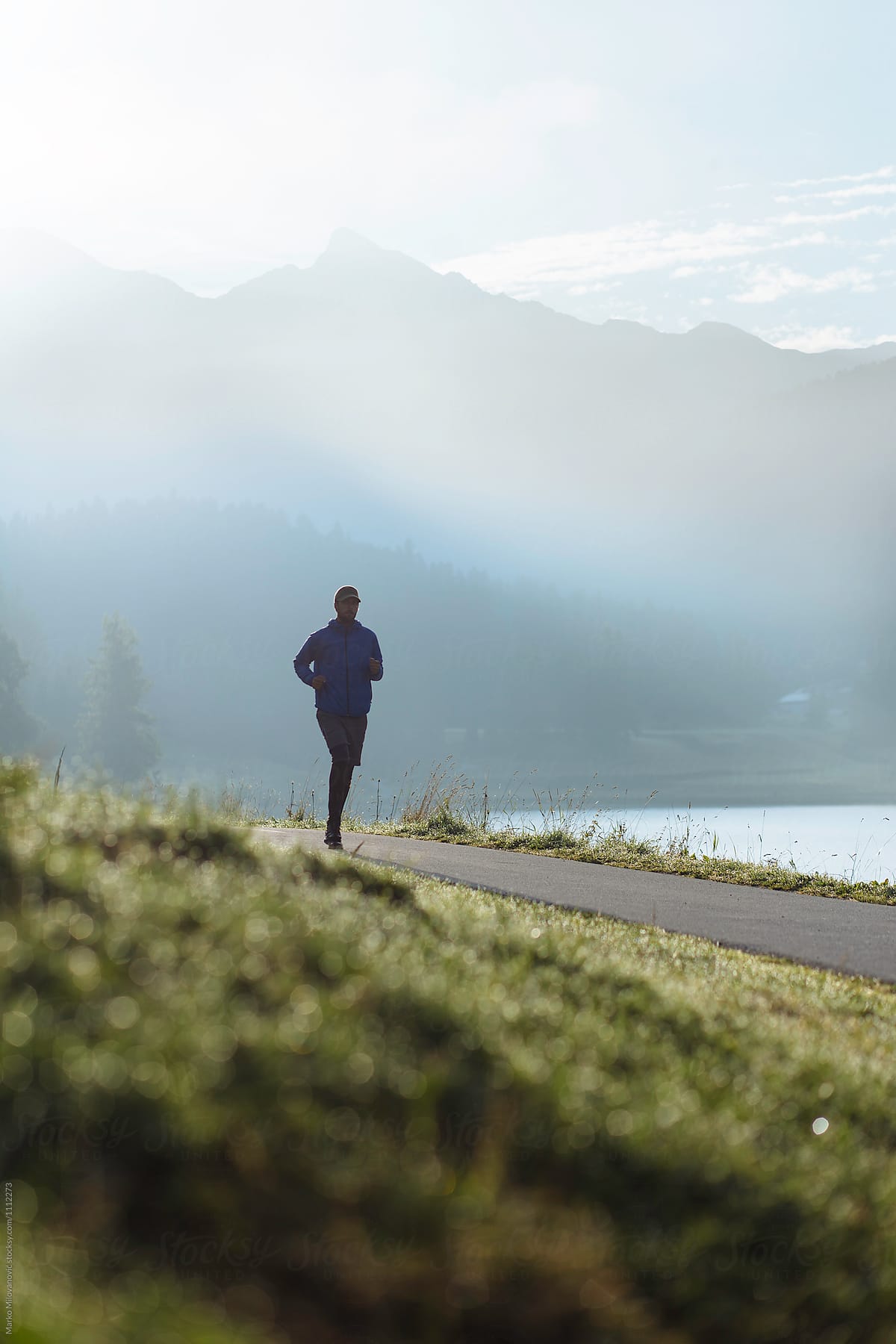 "Man Running Near The Lake" by Stocksy Contributor "Marko" - Stocksy