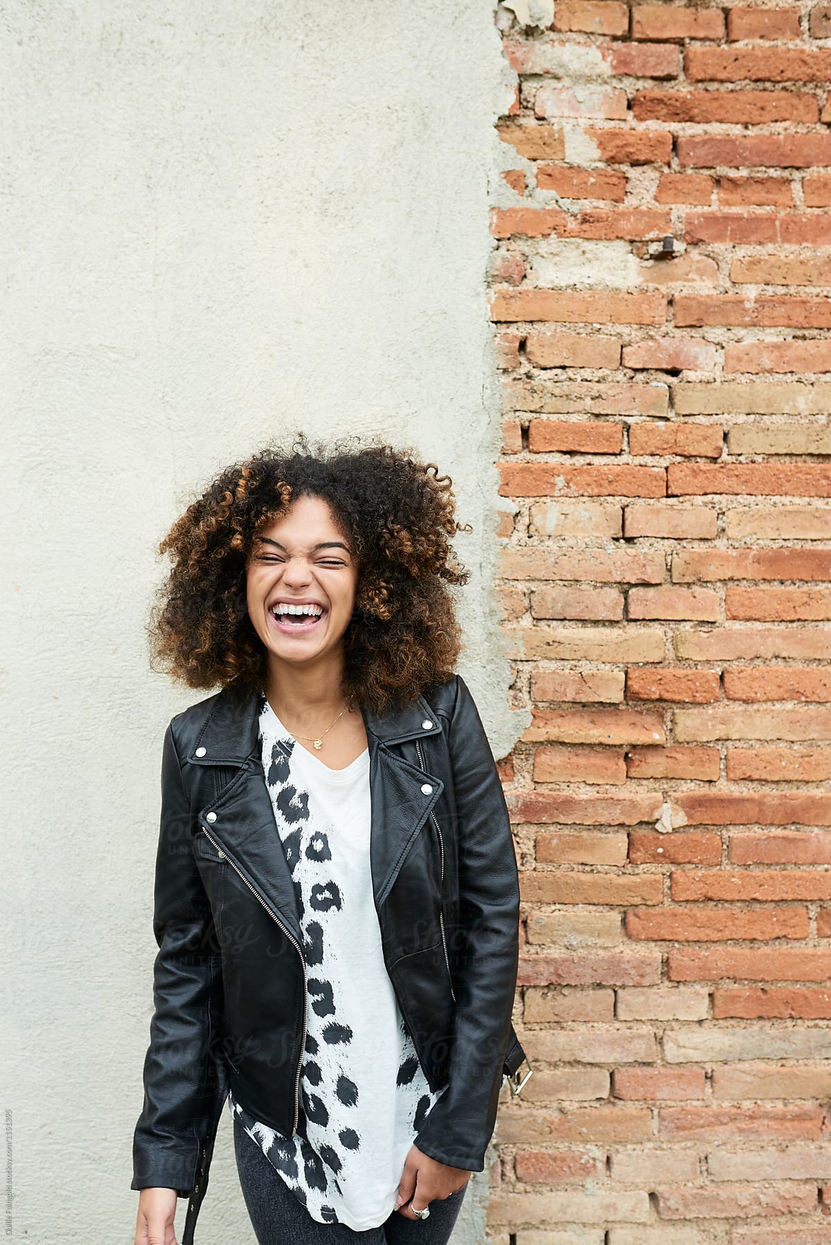 "Curly Laughing Person Against Brick Wall" by Stocksy Contributor ...